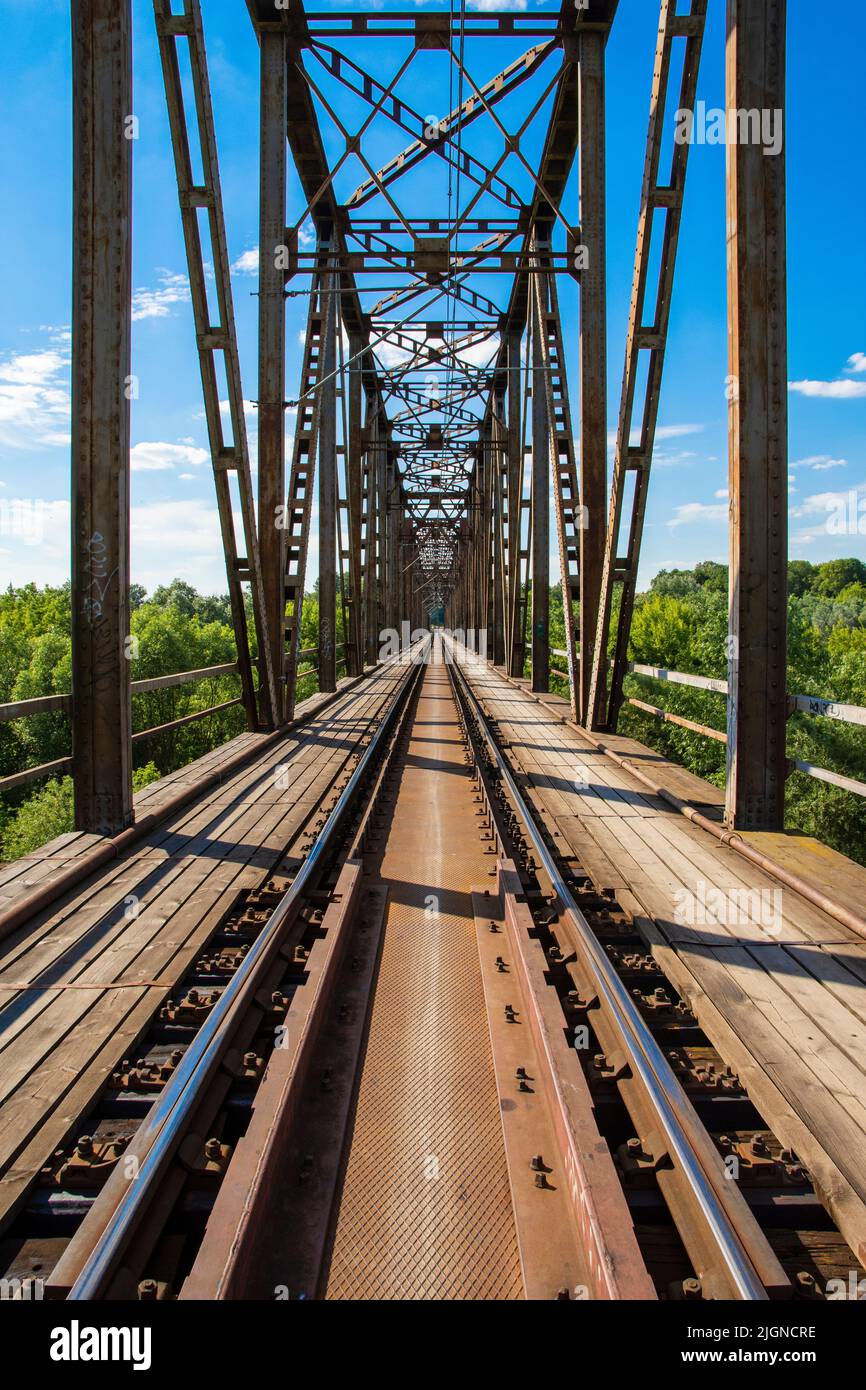 The metal structure of the railway viaduct over the river against the ...