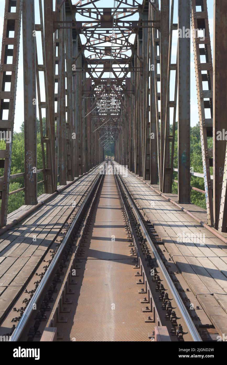 The metal structure of the railway viaduct over the river against the ...