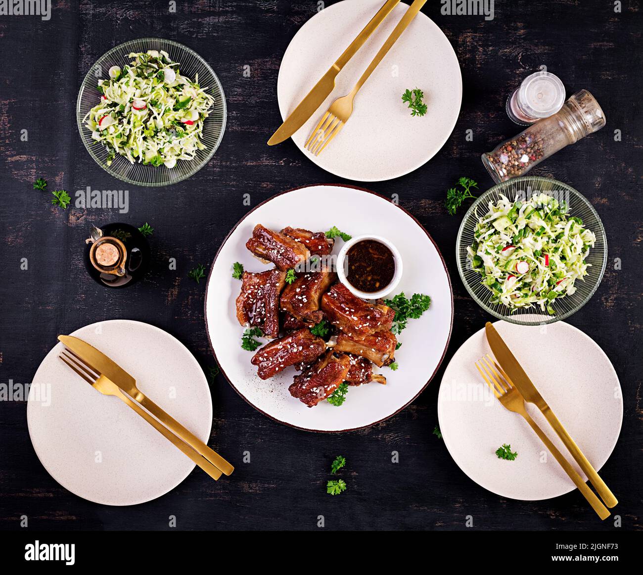 Delicious barbecued spare ribs on plate on dark background. Tasty bbq ...