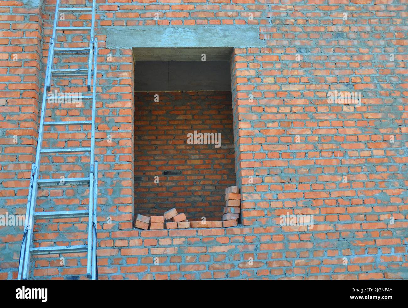 Brick house wall under construction with metal ladder Stock Photo - Alamy