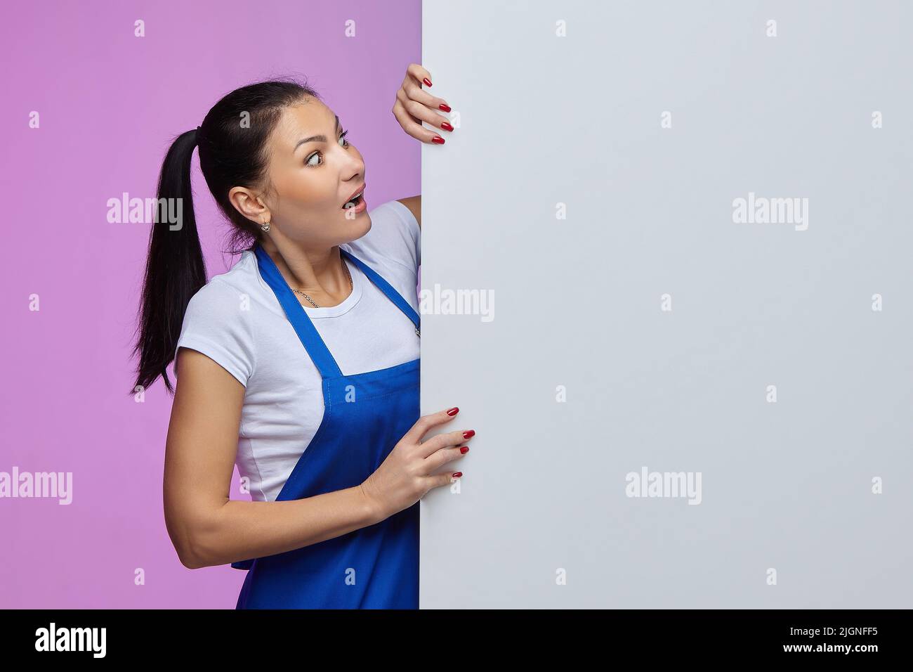 working girl in a blue apron of Asian appearance poses with a white ...