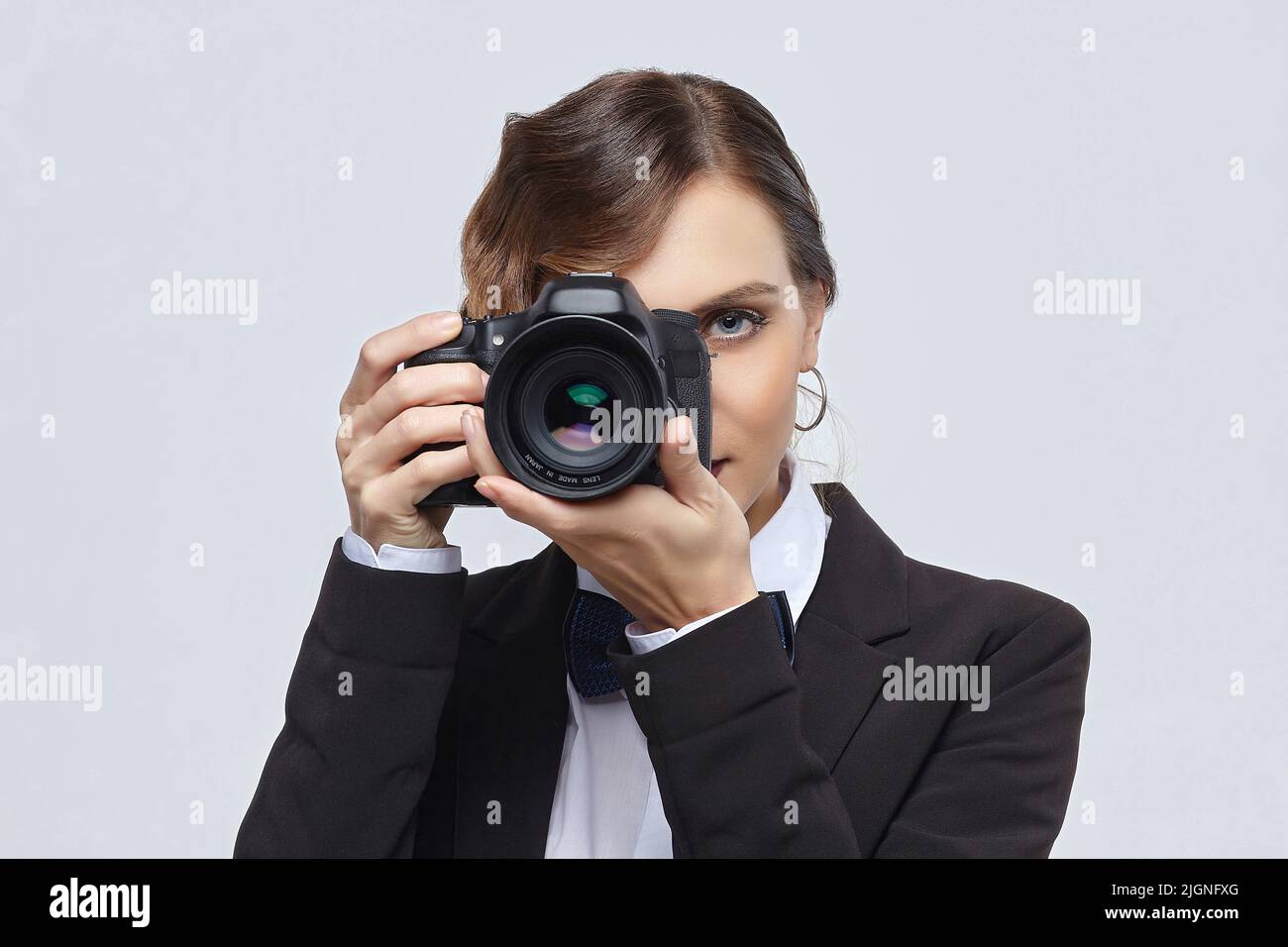 pretty girl photographer in a men's suit and retro hairstyle. posing ...