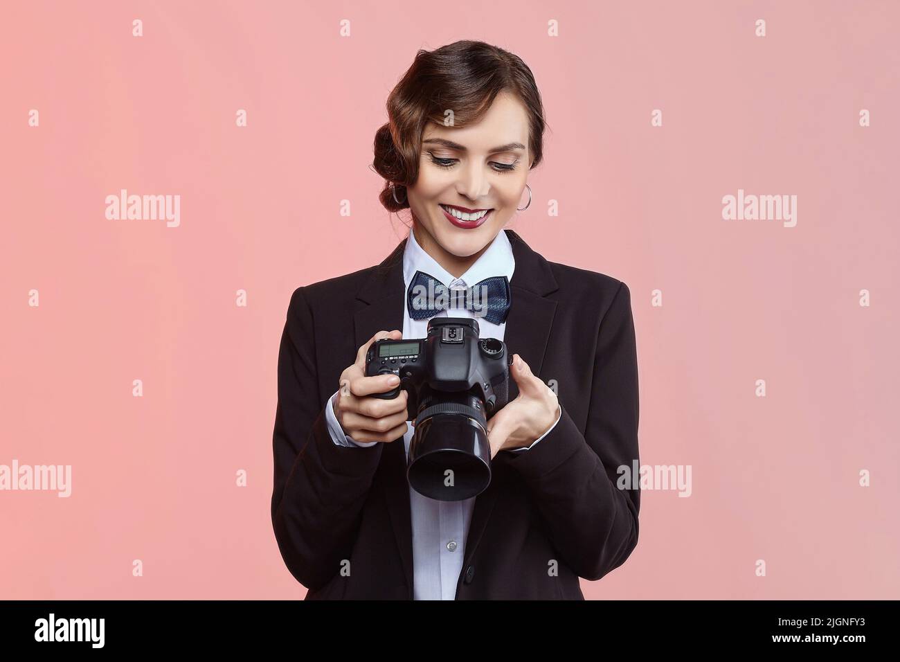 pretty girl photographer in a men's suit and retro hairstyle. posing ...