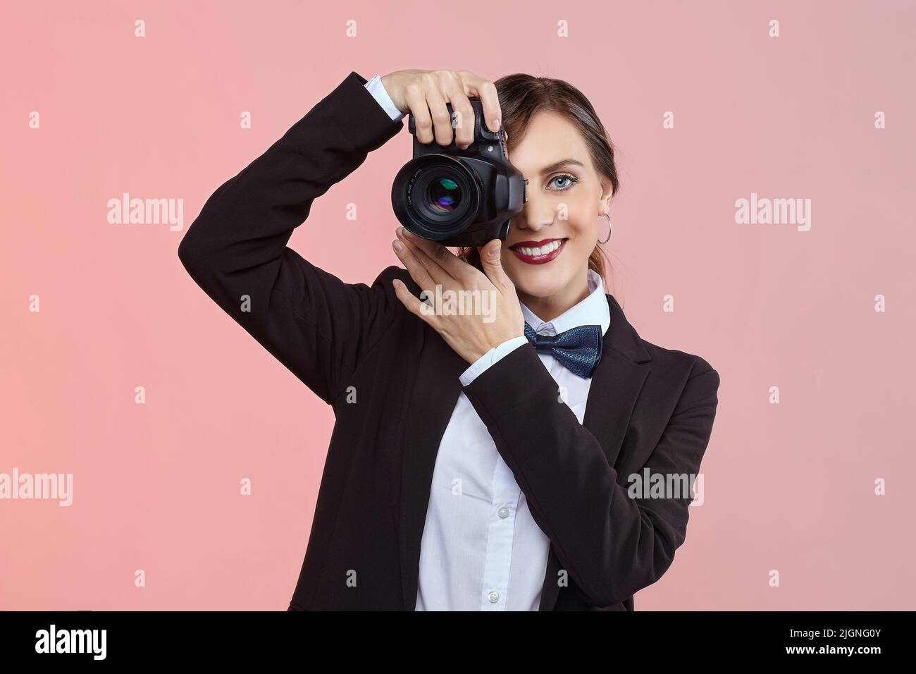 pretty girl photographer in a men's suit and retro hairstyle. posing ...