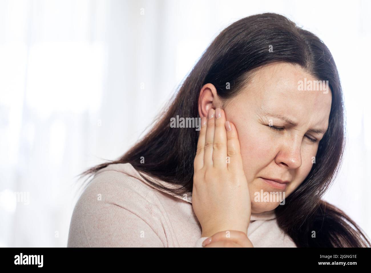 Young woman have a headache migraine stress or tinnitus - noise ...