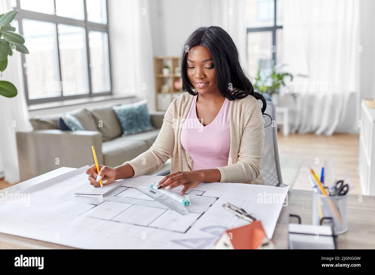 female architect with house model and blueprint Stock Photo - Alamy