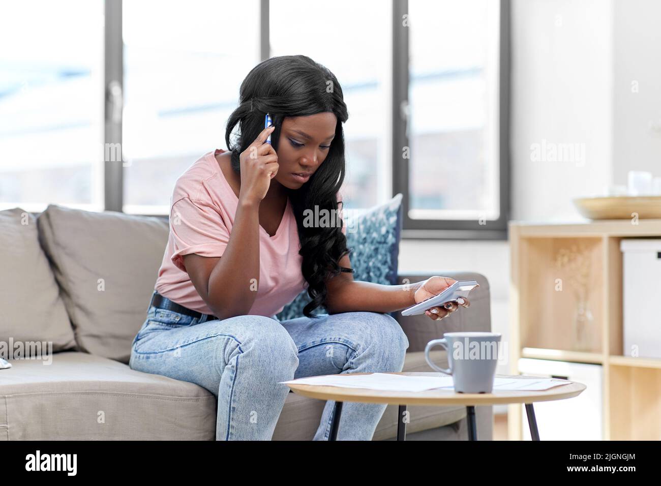 african woman with papers and calculator at home Stock Photo - Alamy
