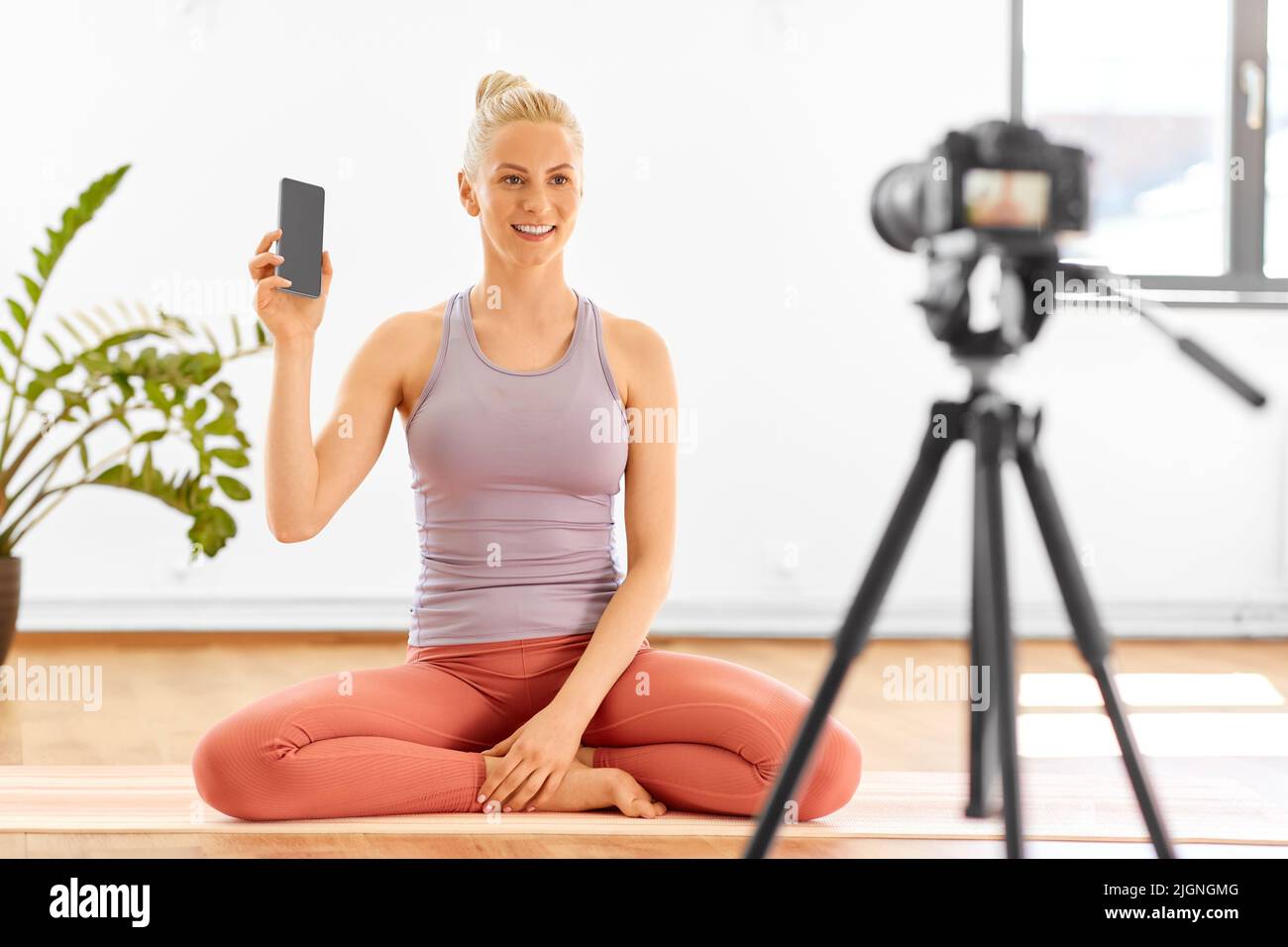 woman with phone streaming for yoga blog at home Stock Photo - Alamy