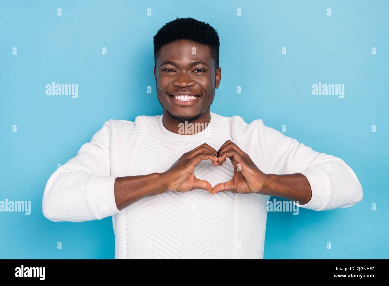 Photo of good mood cute man adore admire his girlfriend showing heart ...