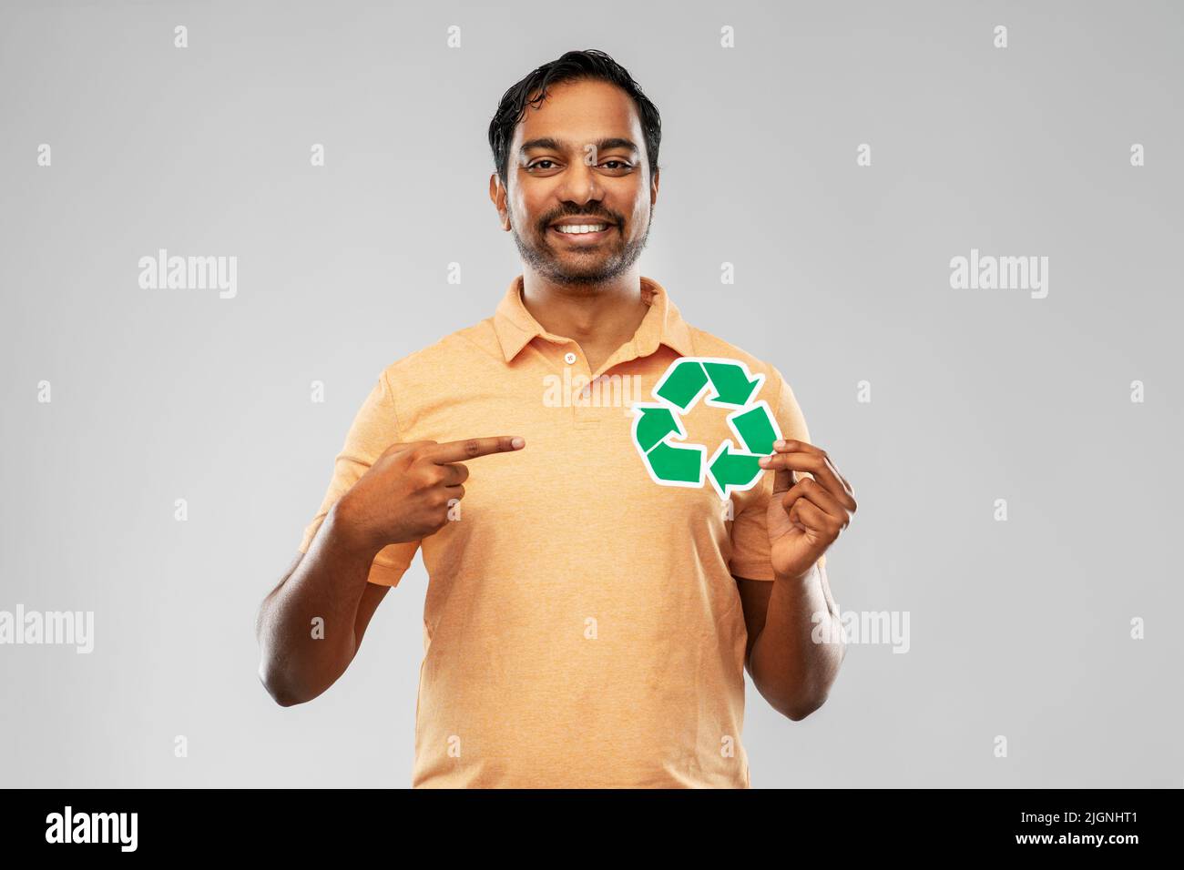 smiling indian man holding green recycling sign Stock Photo - Alamy
