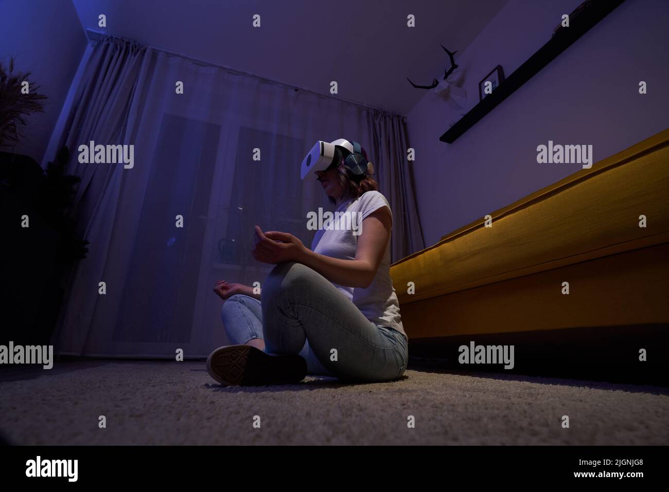 Woman uses virtual reality glasses to relax and meditate. Concept of ...