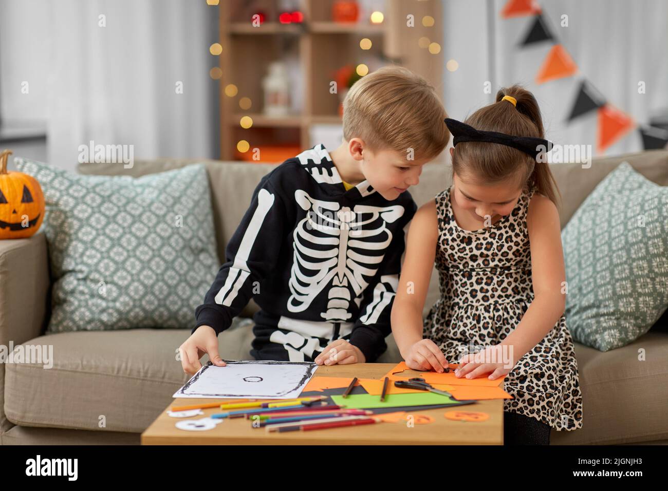 kids in halloween costumes doing crafts at home Stock Photo - Alamy
