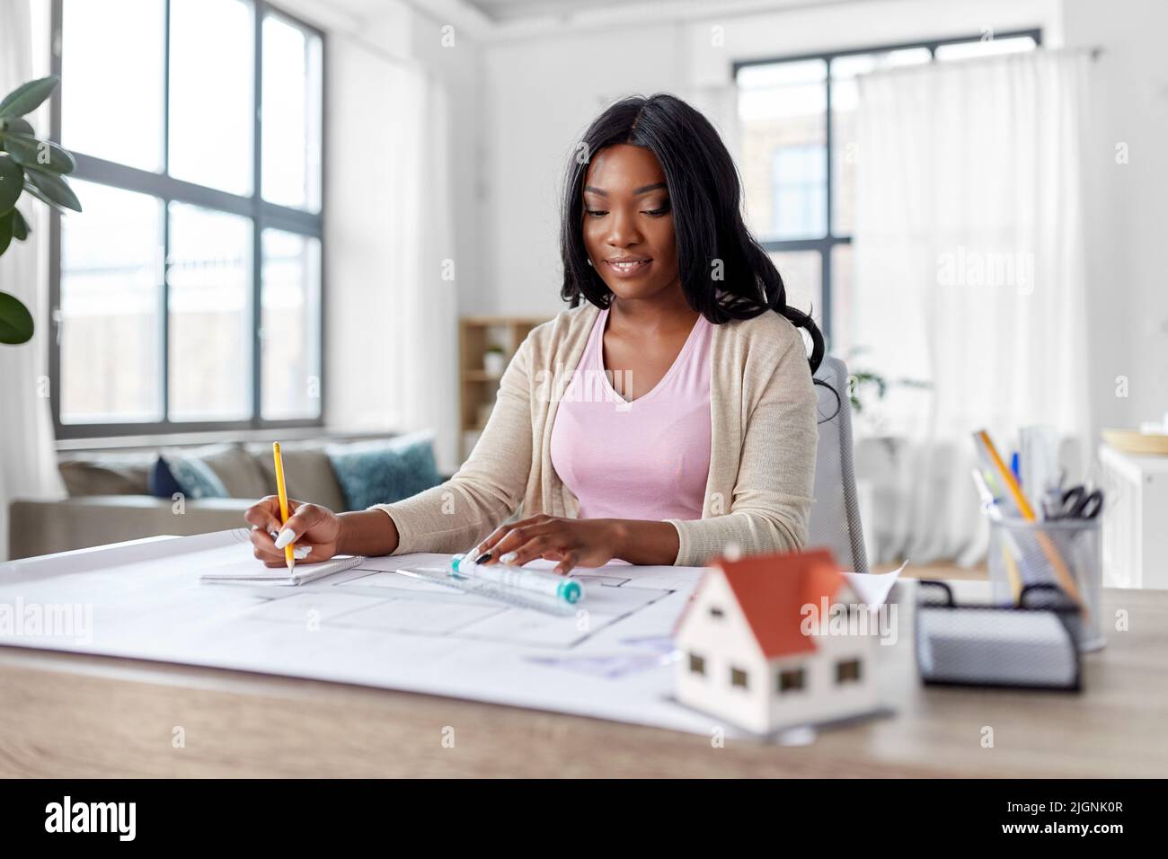 female architect with house model and blueprint Stock Photo - Alamy