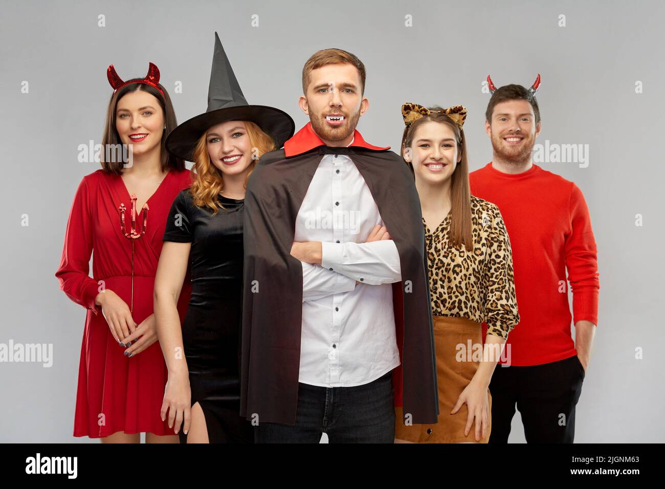 happy friends in halloween costumes over grey Stock Photo - Alamy