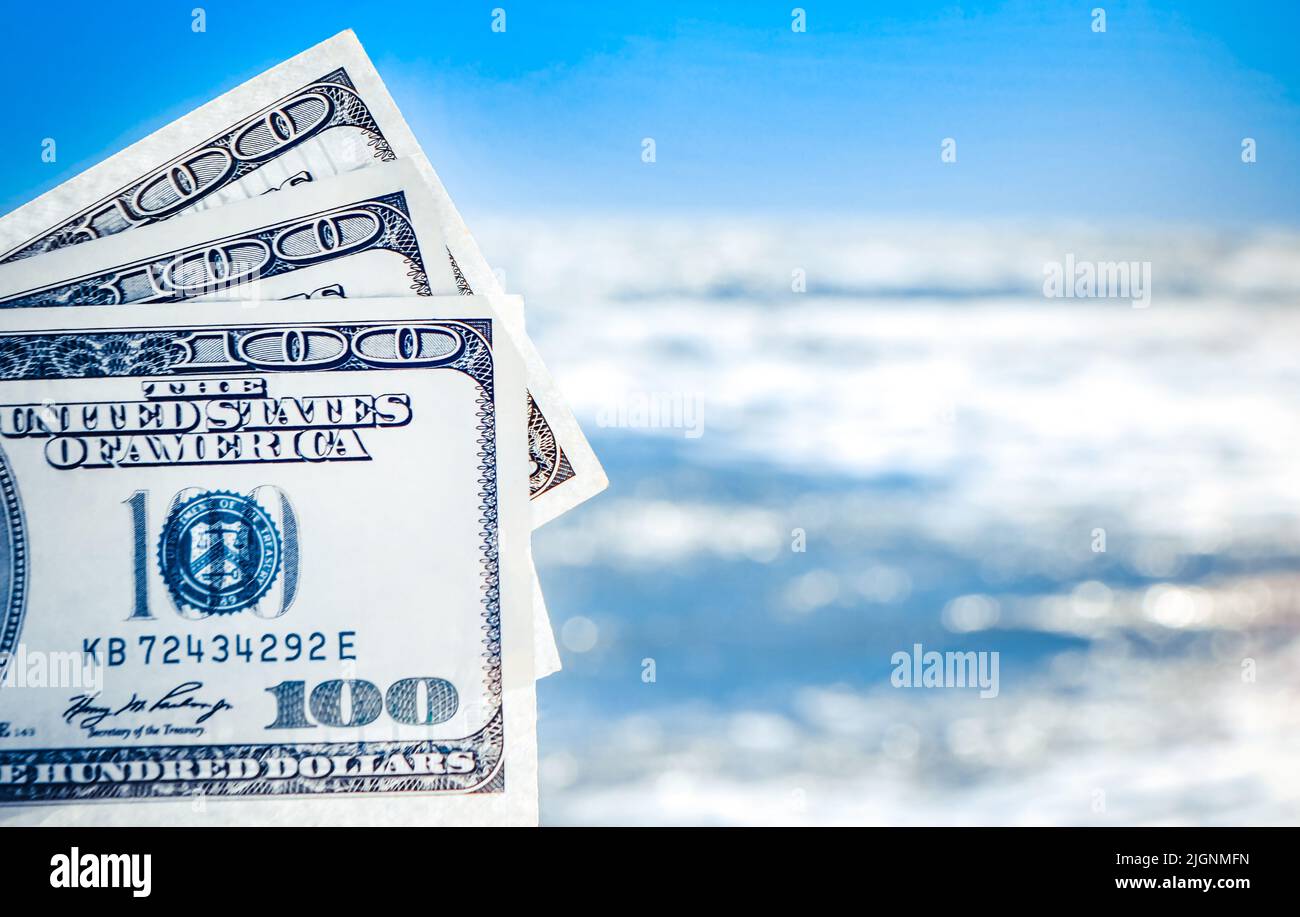 Girl holding money bill of 300 dollars on background of sea ocean waves ...