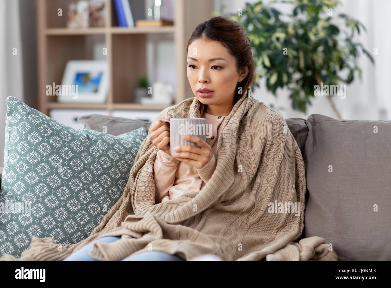 sad sick asian woman drinking hot tea at home Stock Photo - Alamy