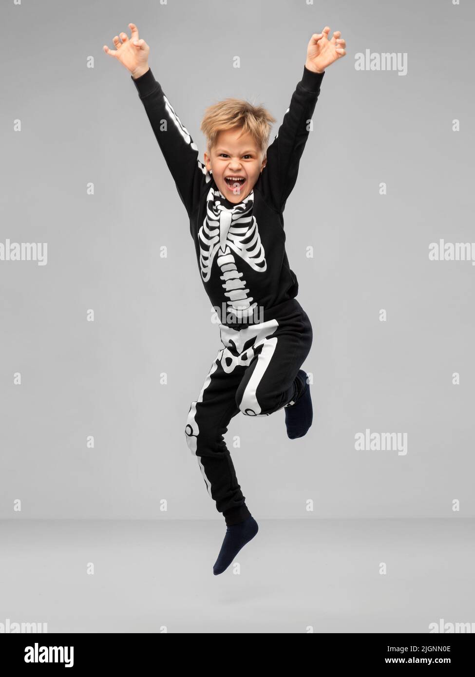 happy boy in halloween costume of skeleton jumping Stock Photo - Alamy