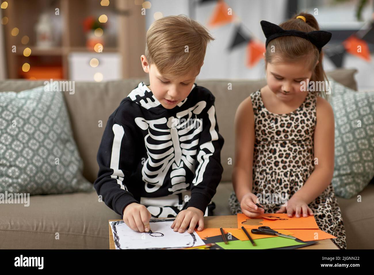kids in halloween costumes doing crafts at home Stock Photo - Alamy
