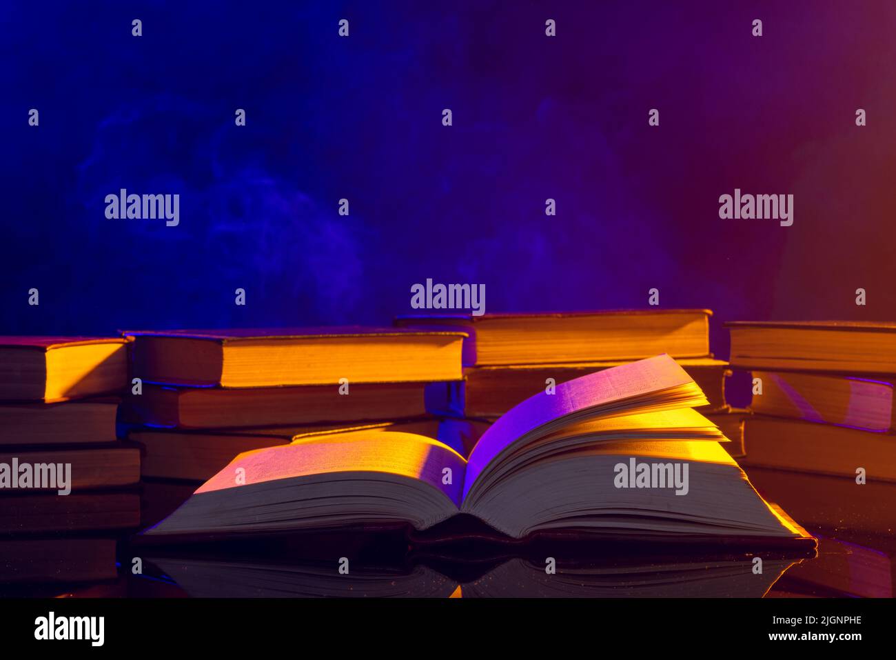 Composition of multiple books on table over smoke on black background ...