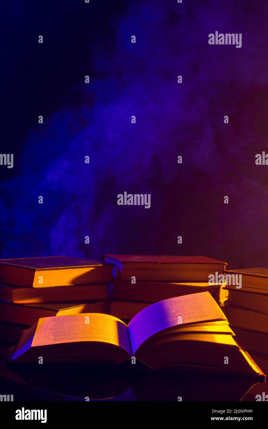 Composition of multiple books on table over smoke on black background ...