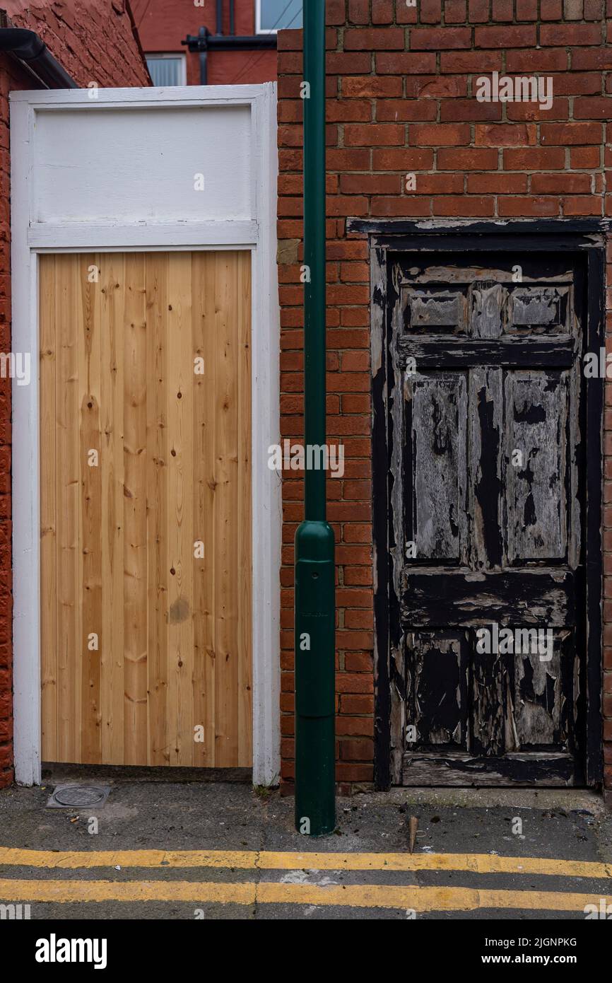 two wooden doors, one new, one old, with lamp post between and two ...