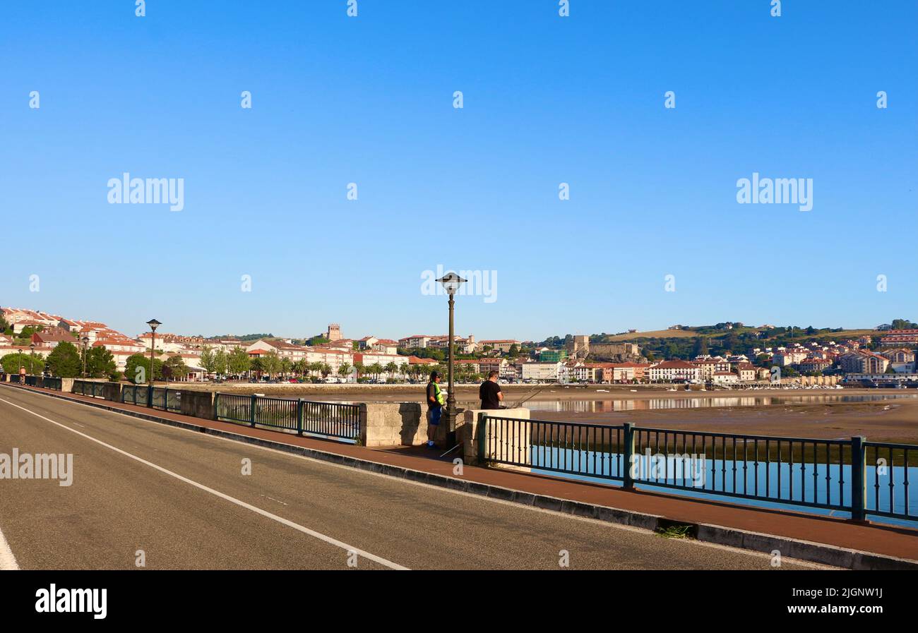 Men rod and line fishing from the Maza road bridge in the Spanish town ...