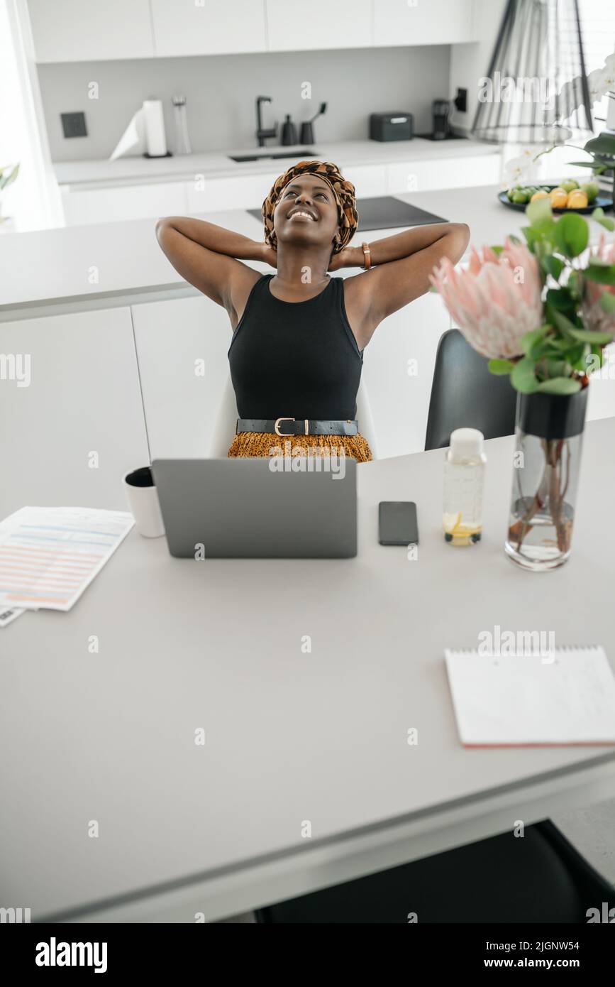 African traditional business woman working from home. Looking up ...