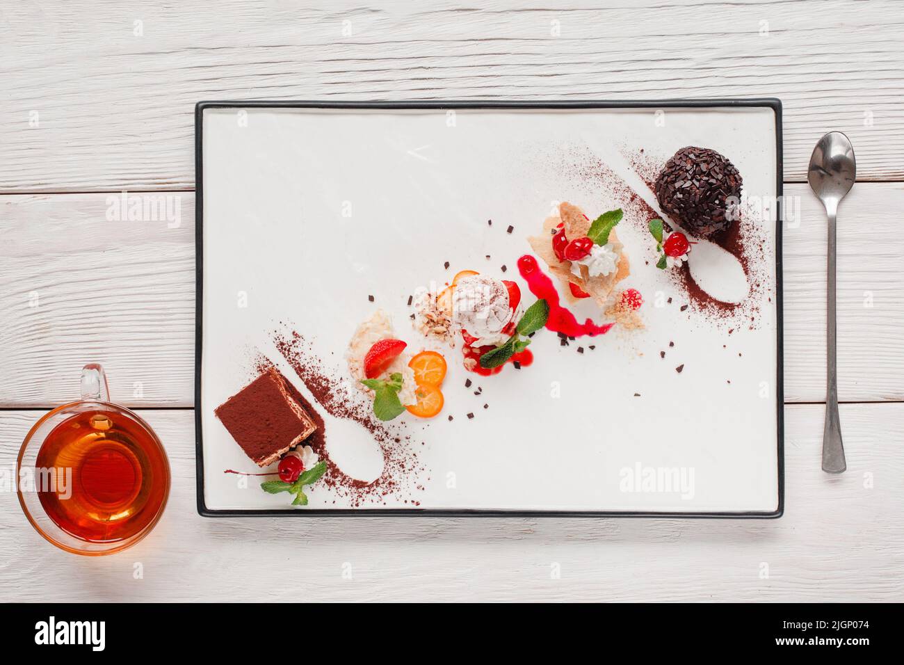 Variety of desserts with tea and spoon flat lay Stock Photo - Alamy