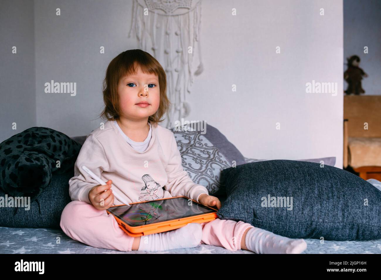 Child using technology. Toddler at home with a tablet and a pen stylus ...