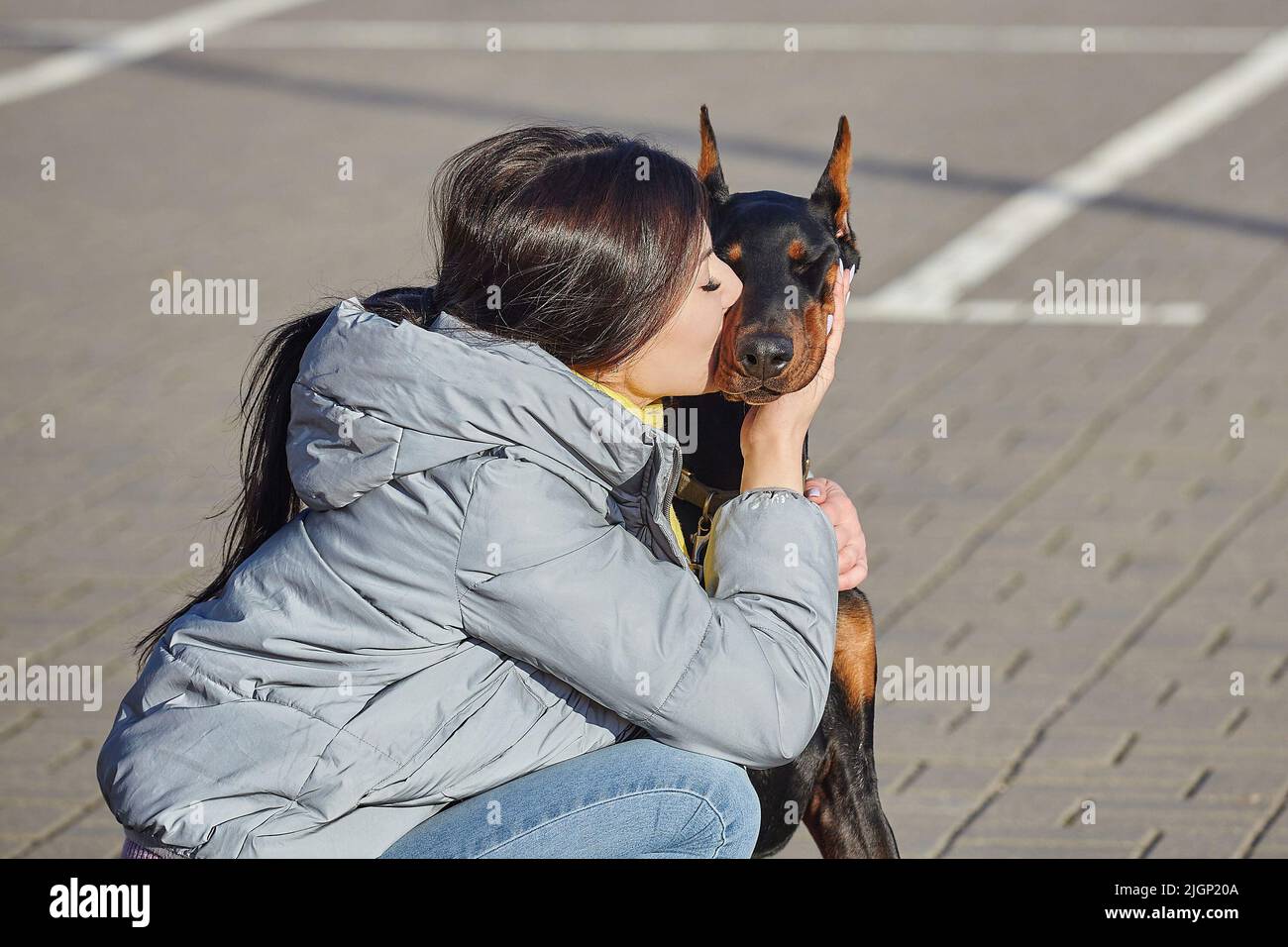 young girl kisses and hugs her dog doberman Stock Photo - Alamy