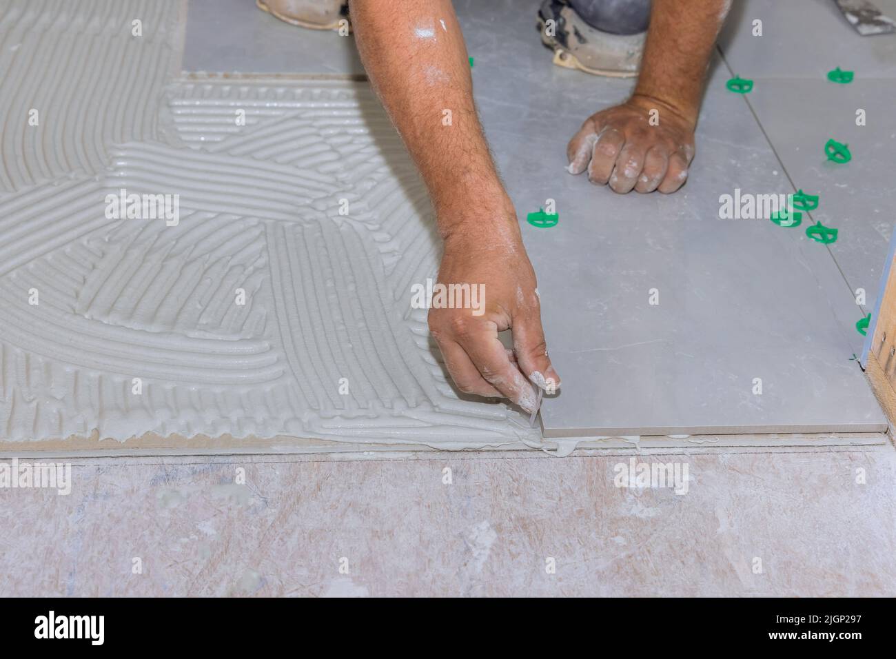 Construction worker installing tile leveling hi-res stock photography ...