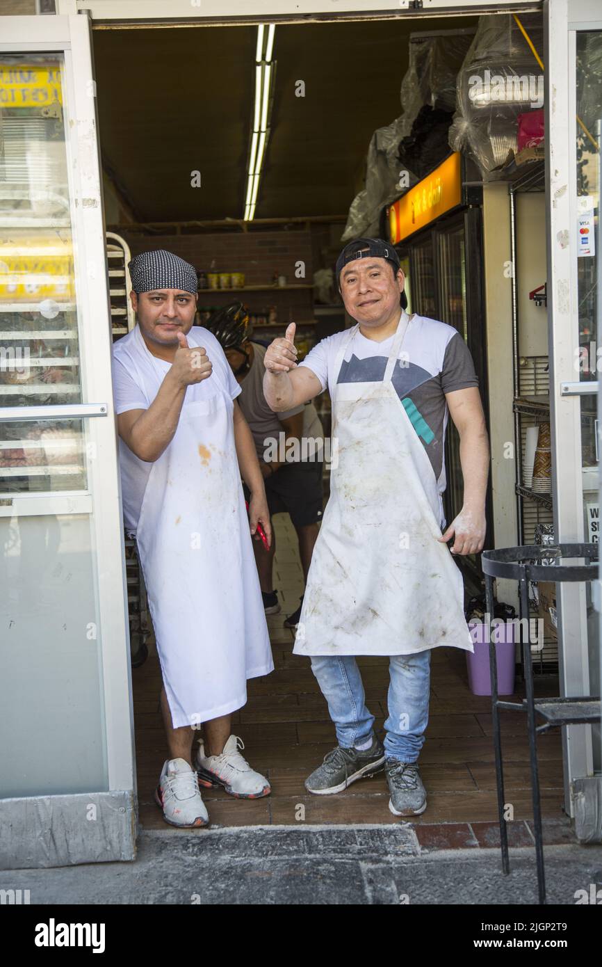 Kitchen staff in the doorway of a bakery watching the Indpendence Day ...