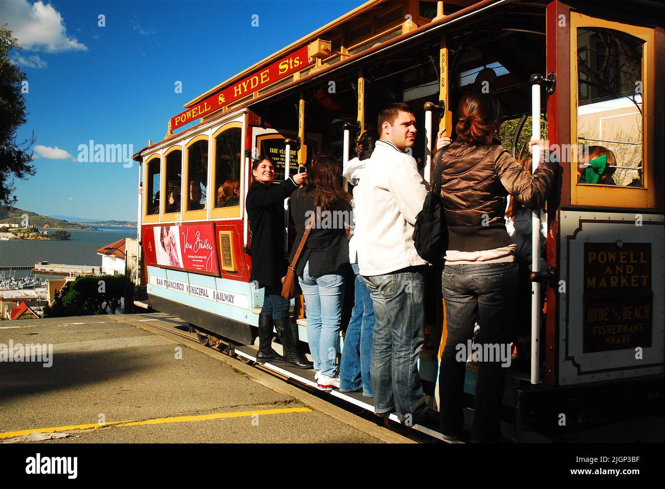 A group of riders hold on to the posts as they ride up Russian Hill on ...