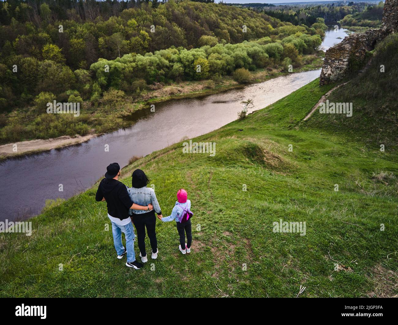 Mother, father daughter enjoys the view on the coast Sluch river hills ...