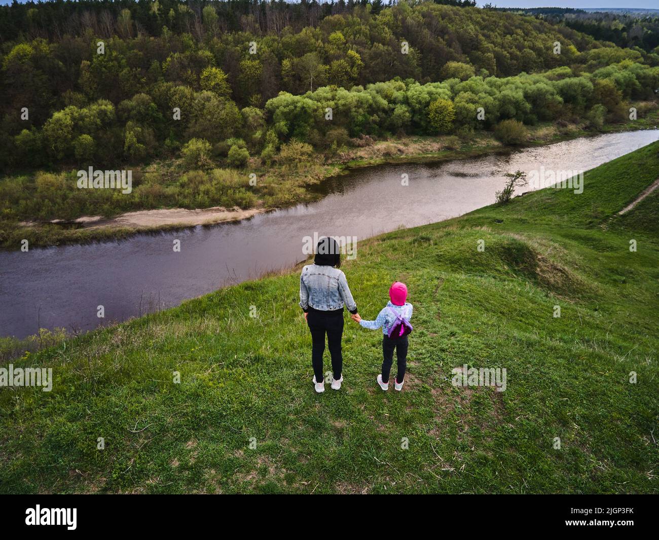 Mother and daughter enjoys the view on the coast Sluch river hills ...
