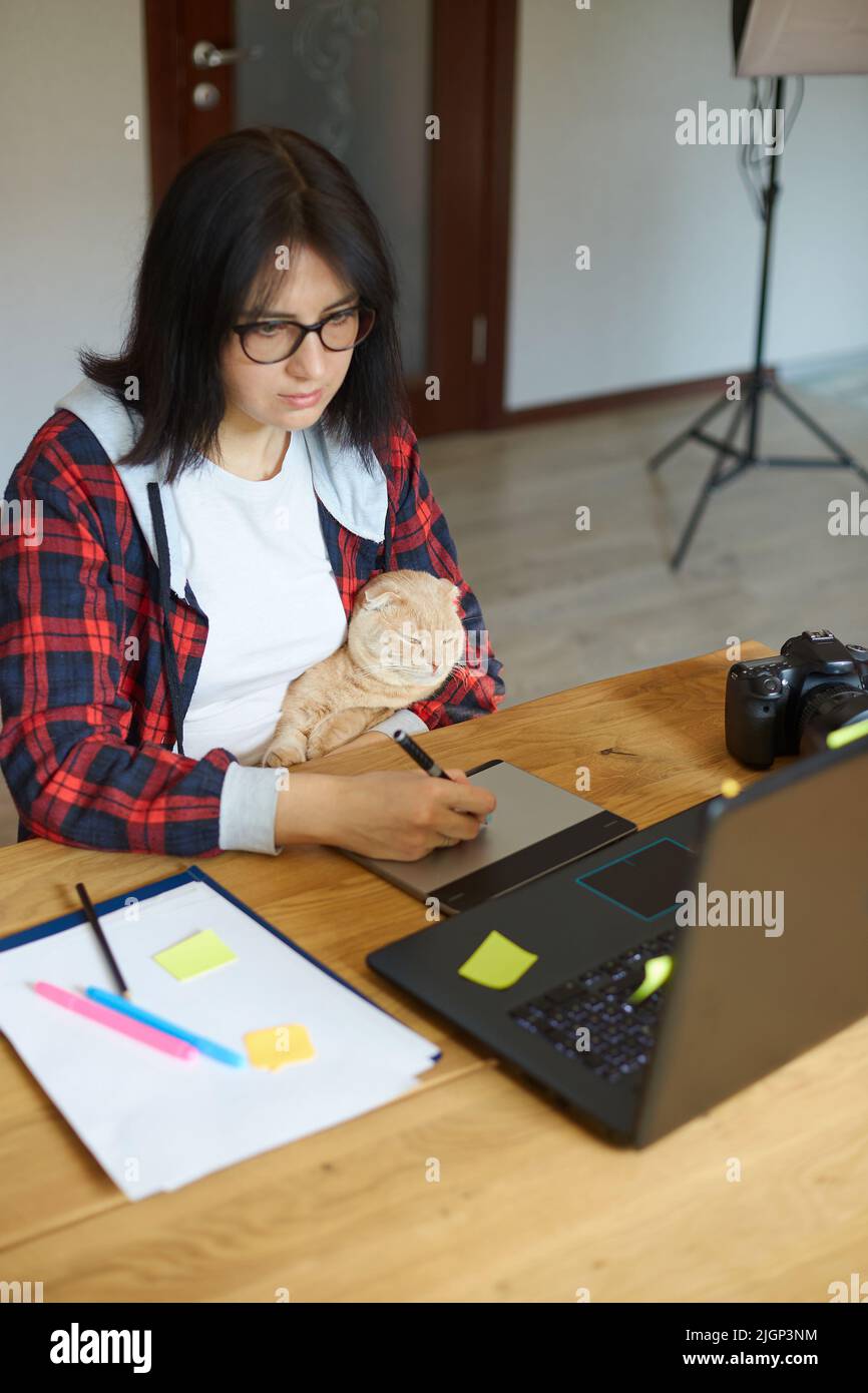 Creative female photographer with cute cat, using graphic drawing ...