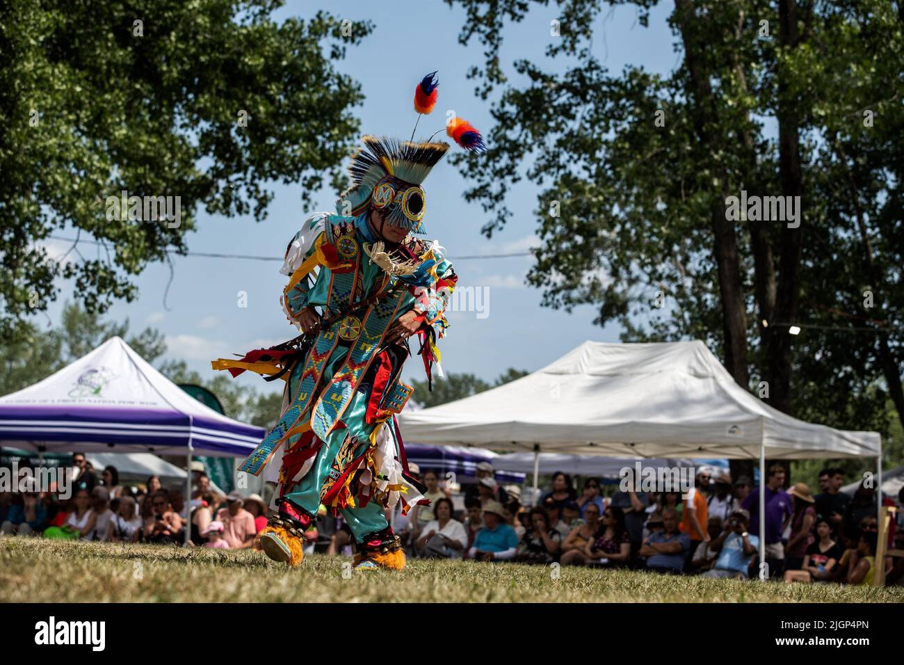 A pow-wow dancer doing a traditional dance in the arena during the ...