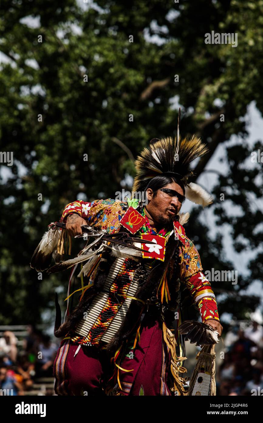 A pow-wow dancer doing a traditional dance in the arena during the ...