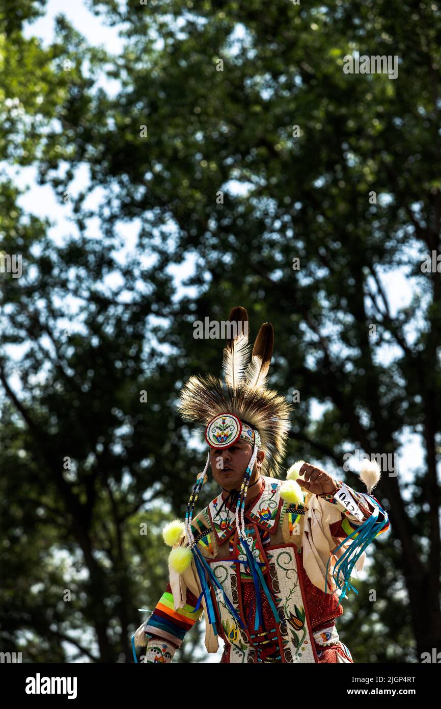 A pow-wow dancer doing a traditional dance in the arena during the ...