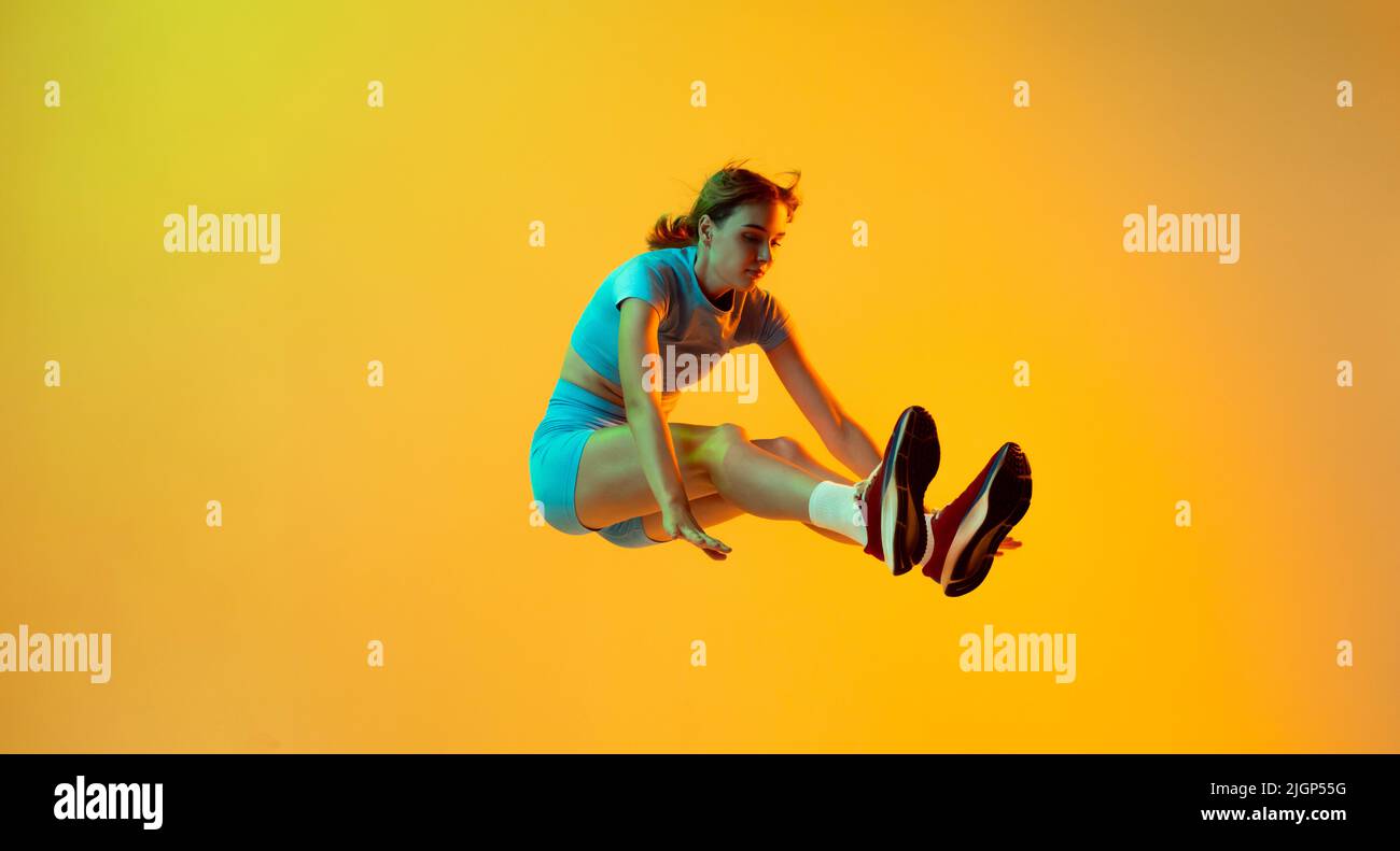 Professional longjumper. One female athlete in sports uniform jumping ...