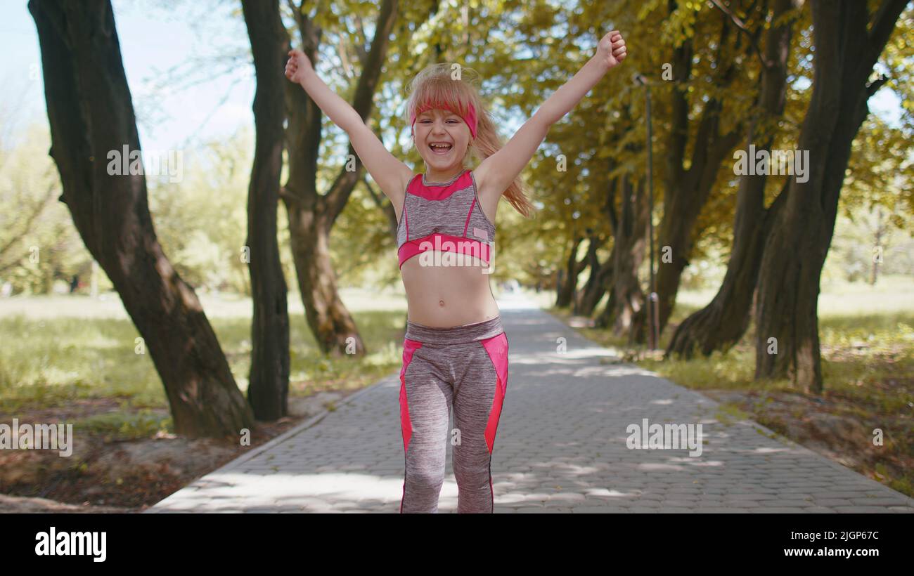 Athletic fitness sport runner child girl finishing racing competition, victory. Celebrating ...