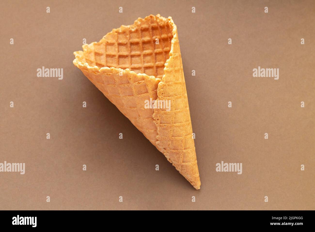 Single empty wafer ice cream cone on brown table. Top view Stock Photo ...