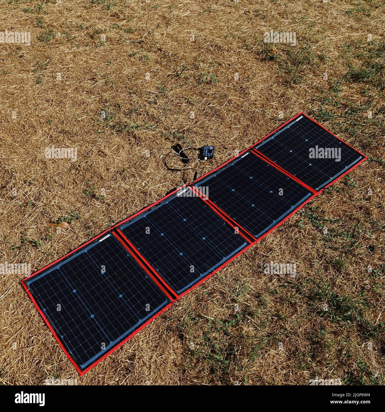 A foldable, portable solar panel open on a lawn Stock Photo - Alamy