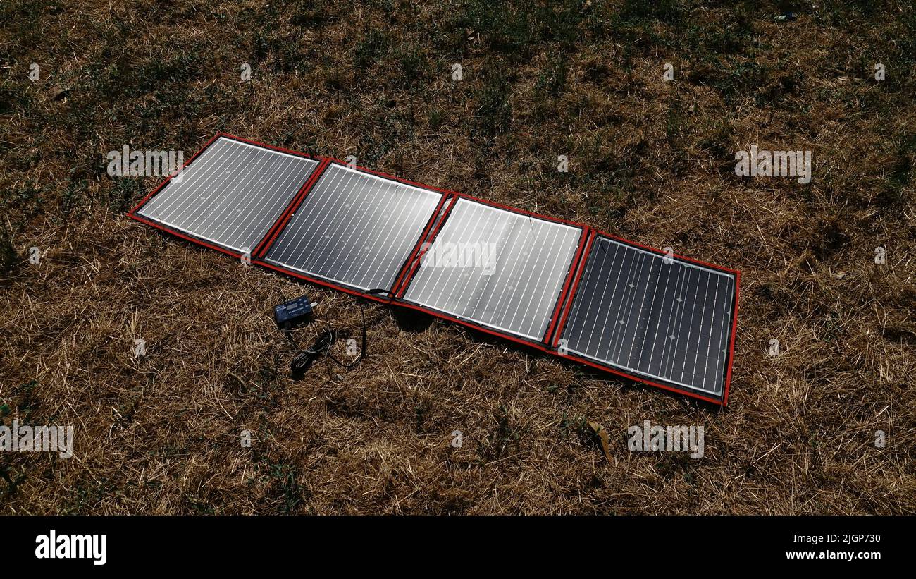 A foldable, portable solar panel open on a lawn Stock Photo - Alamy