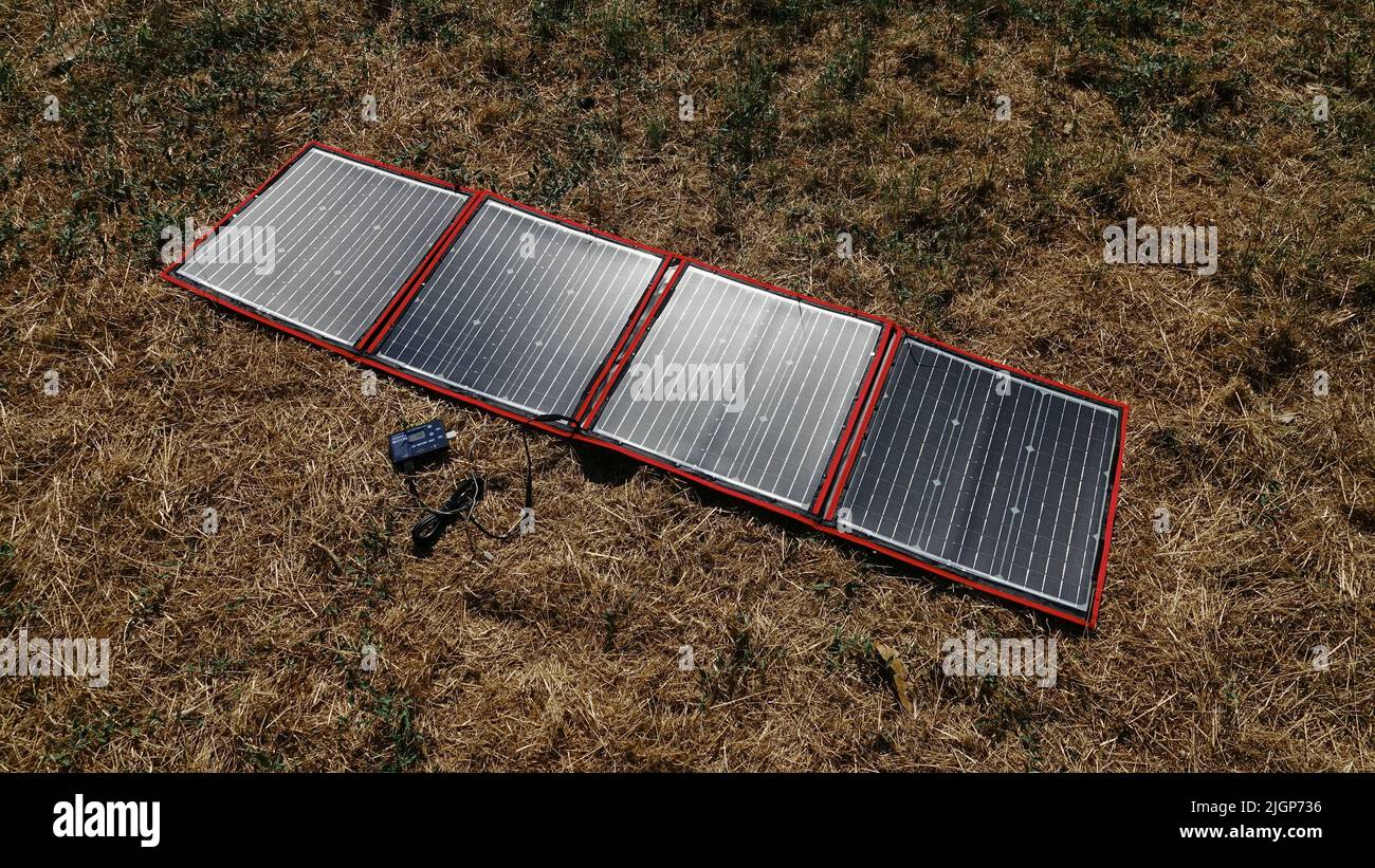 A foldable, portable solar panel open on a lawn Stock Photo - Alamy