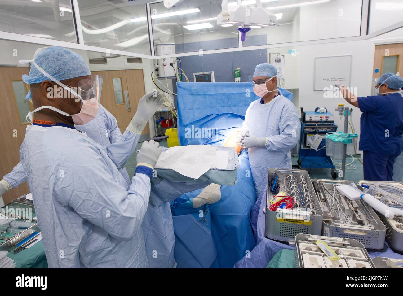 A surgeon and NHS staff perform knee surgery, also known as ...