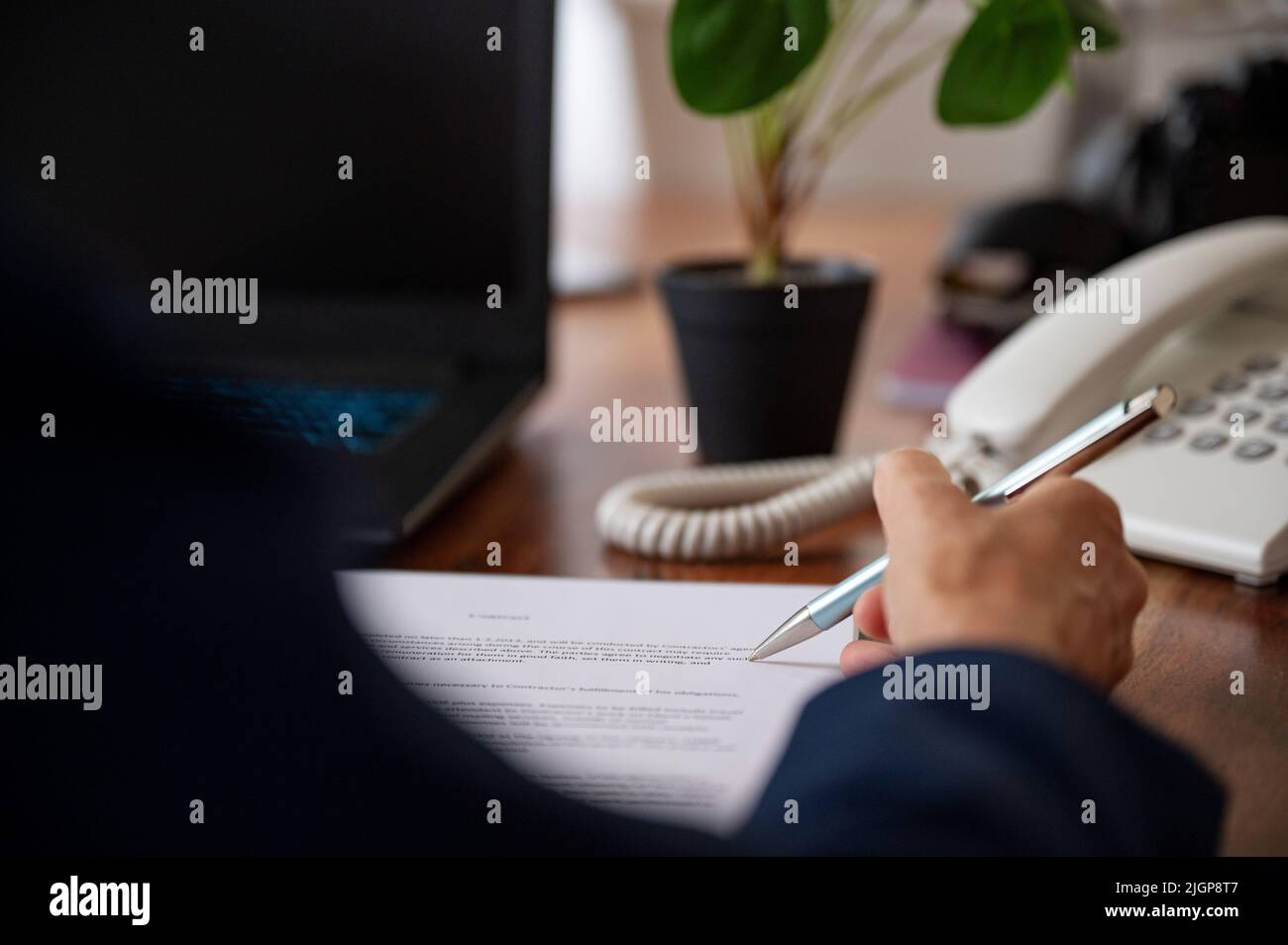 Over the shoulder view of a businesswoman proofreading a contract or ...