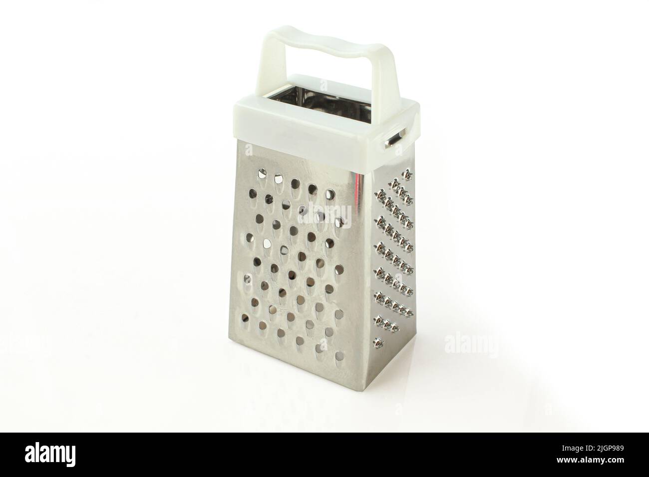 Small mettallic grater with white plastic handle isolated. Slicing ...