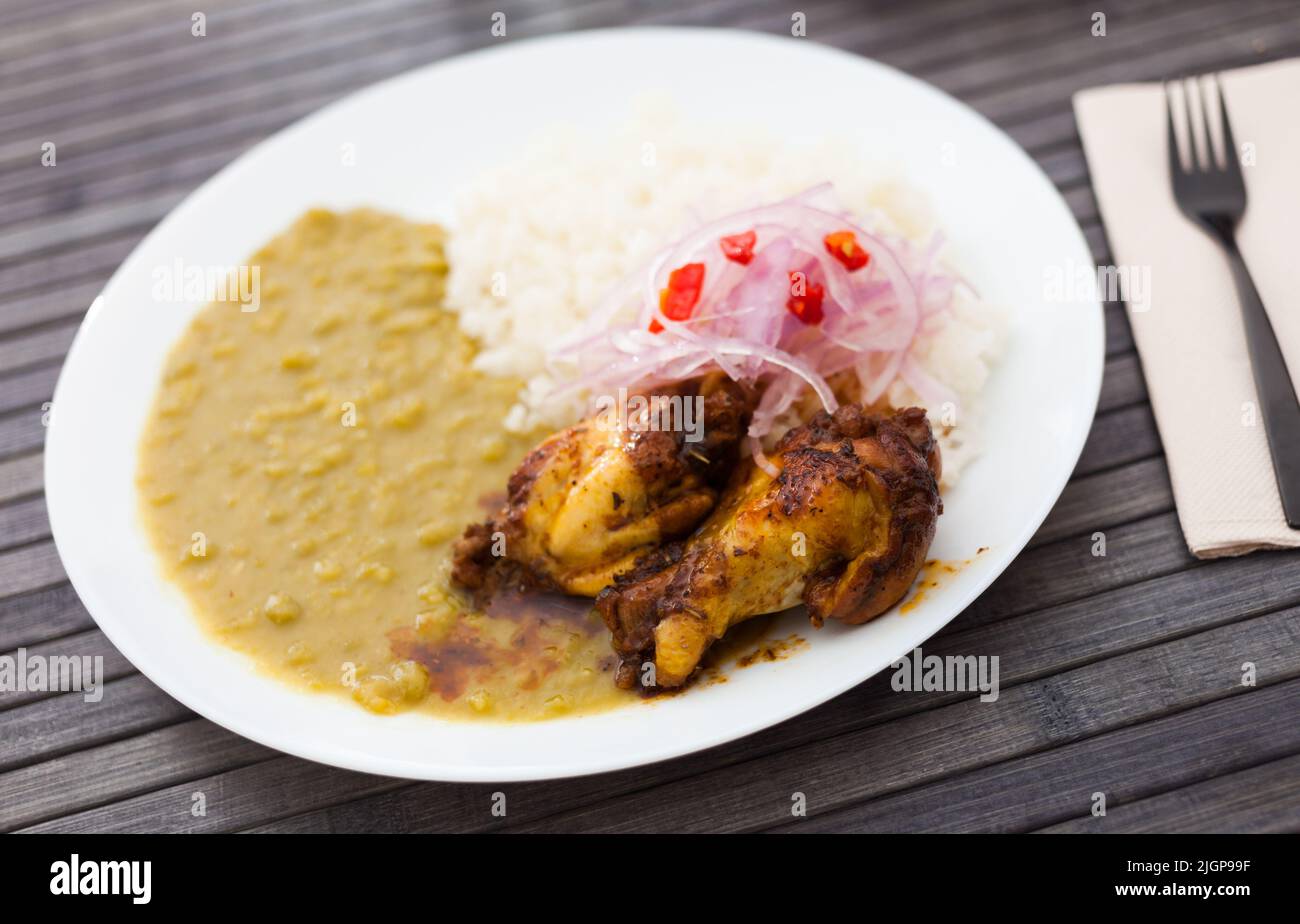 chicken wings with mashed peas, rice and pickled onions on white plate ...