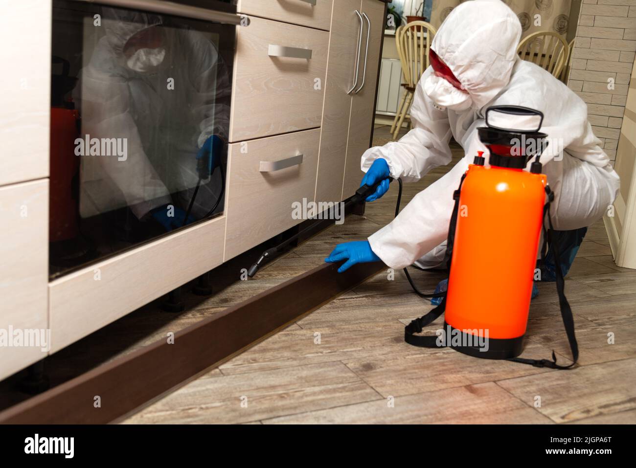 Spray gun with pesticides close-up. An exterminator in work clothes ...